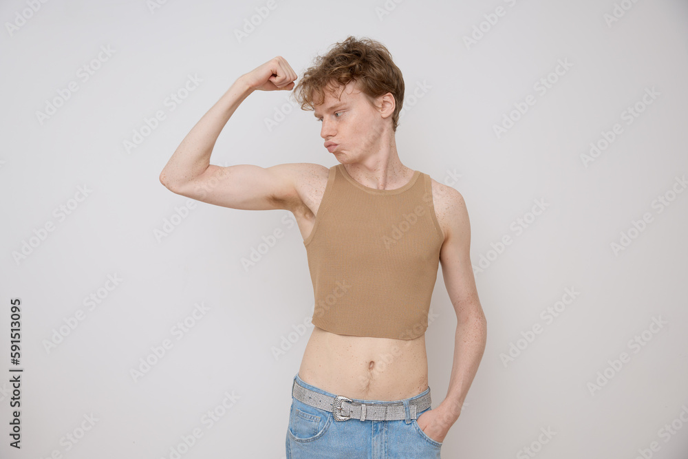 Non-binary stylish person with curly red hair wearing beige crop top ...