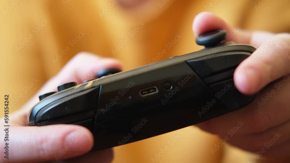 Woman hands holding black joystick gamepad playing game console ...
