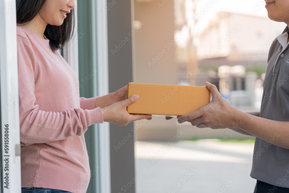 Happy smiling woman receives boxes parcel from courier in front house ...