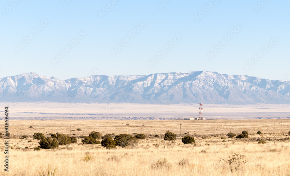 Snow-dusted Sandia Mountains from a distance. Middle distance a cell ...