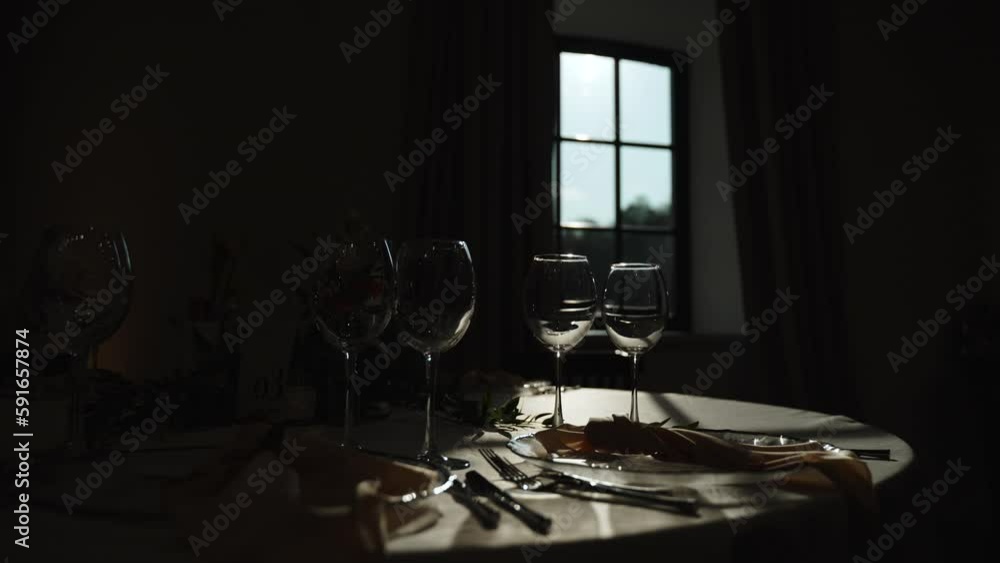 Empty glasses on served round table with cutlery and napkin in dark ...