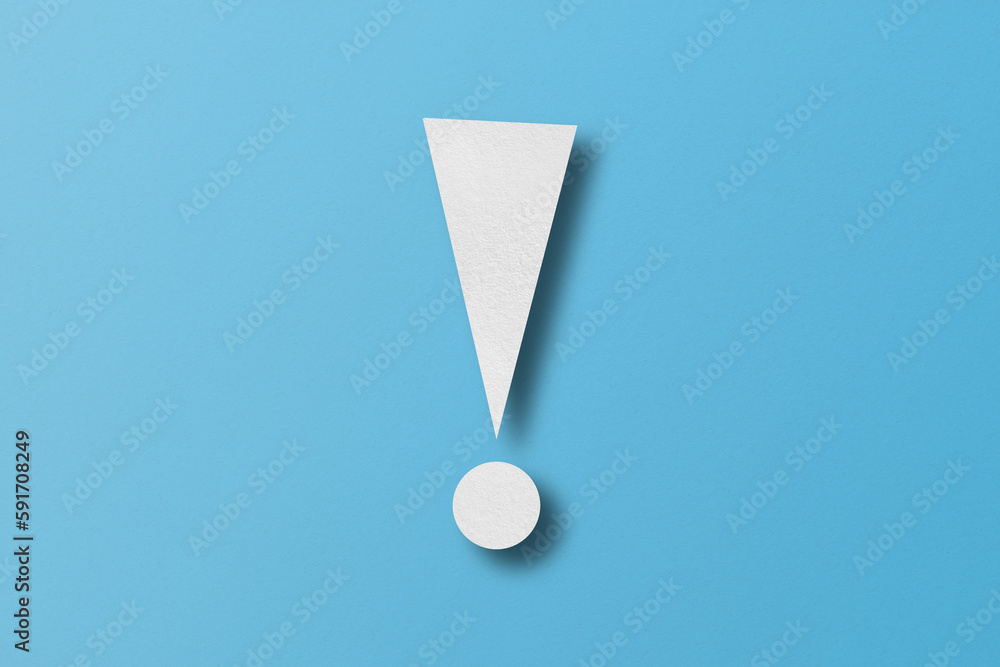 White paper punched into the shape of an exclamation mark. warning sign ...