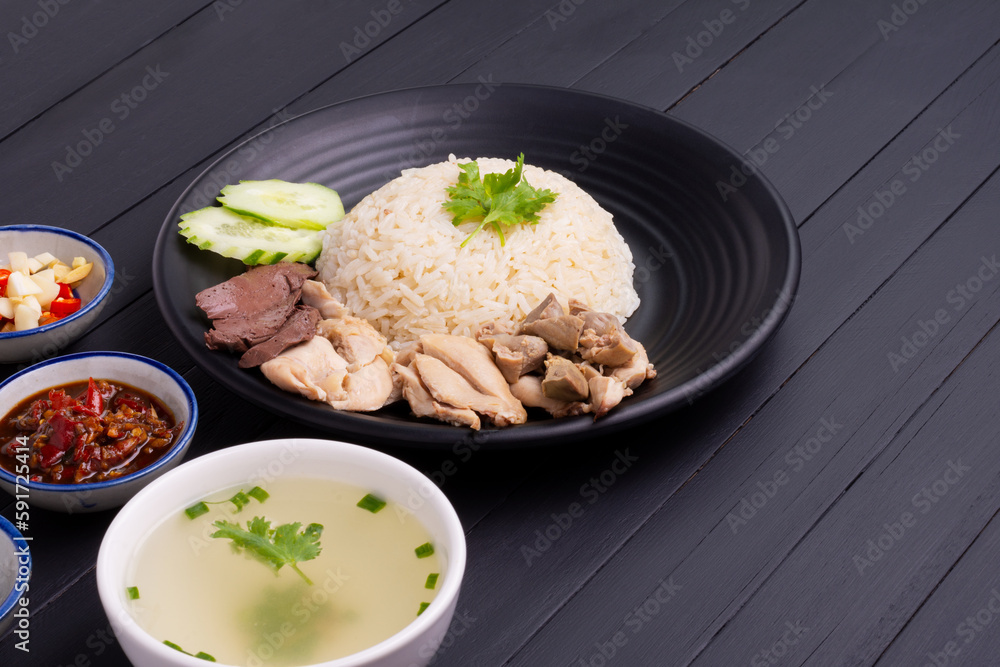 Hainanese chicken rice on a black wooden table background steamed ...