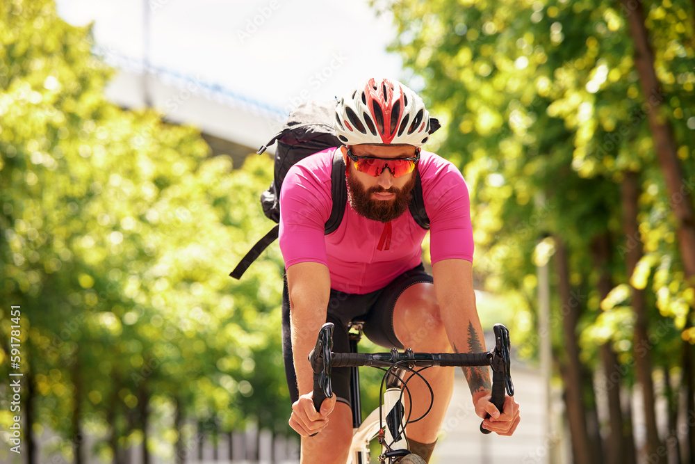 Strong Male cyclist in sportswear, glasses and protective helmet ...