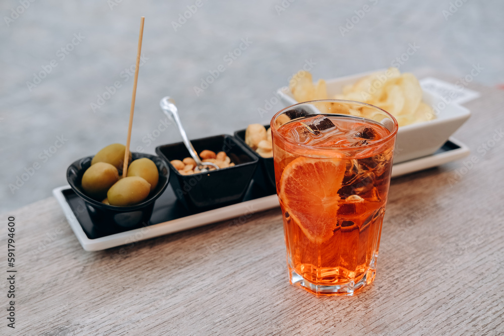 Traditional Italian aperitif cocktail aperol spritz with ice and olives ...