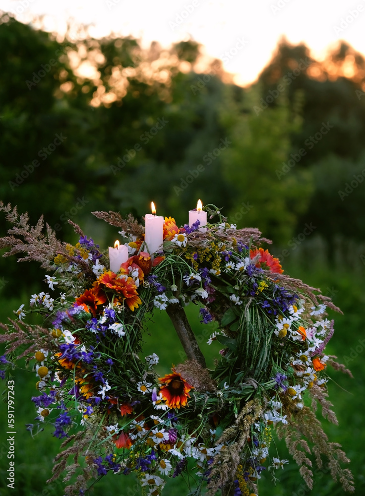 Flower wreath with burning candles on evening natural background ...