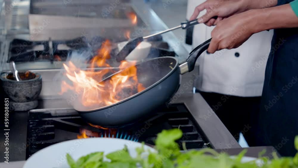 4K Slow, Close-up pan with chef's hand holding pan handle firmly, chef ...