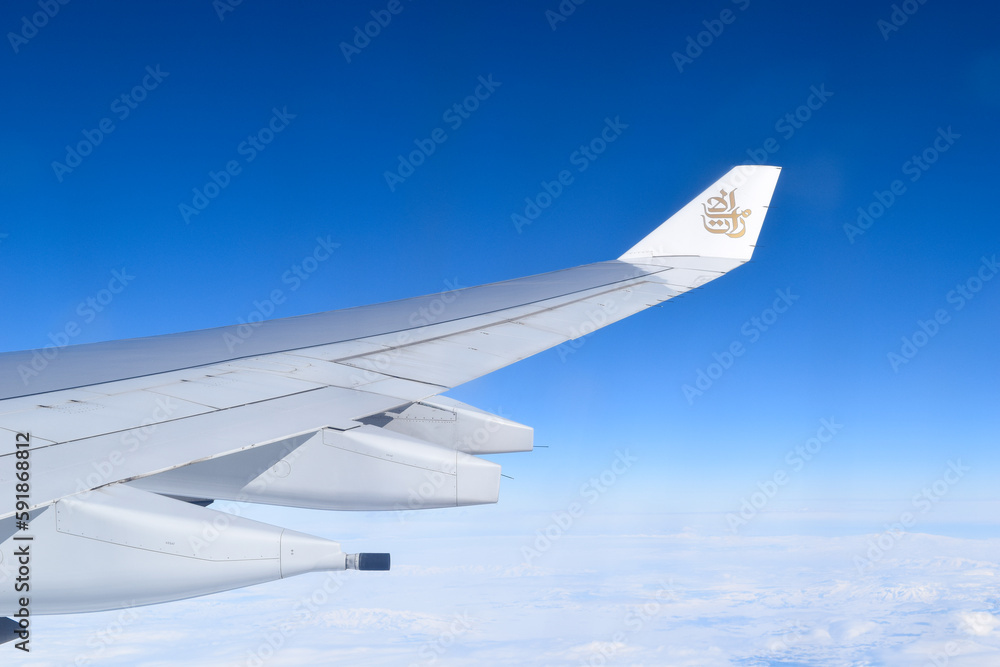 Airplane wing in the sky. Flight above clouds. Emirates airline. Stock ...