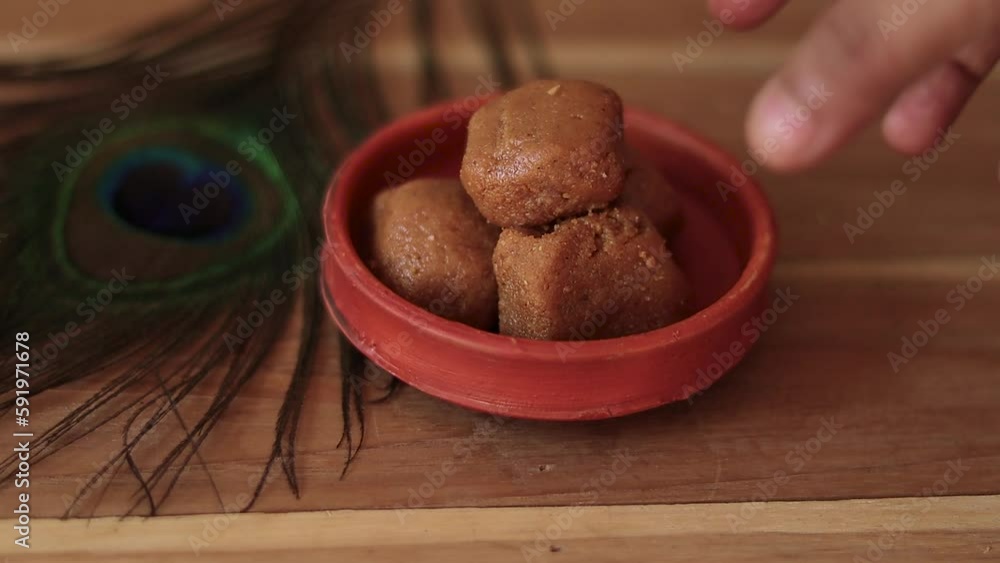 Mathura ka peda is served on a clay plate with peacock feather during ...