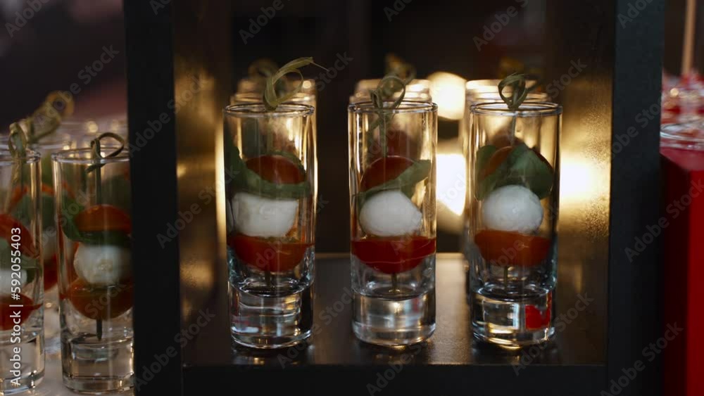 Elegant portioned appetizers of mozzarella with tomatoes and basil in ...