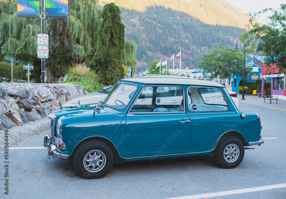 Mini Cooper car parked by the road side. Blue vintage mini car side ...