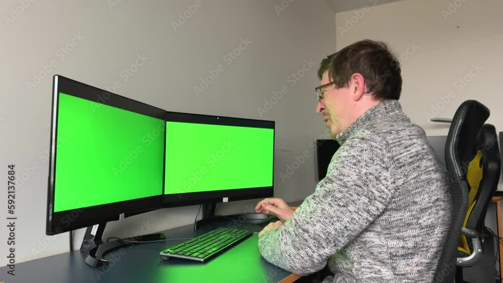 Typing man green screen monitors office A man working in his complete ...