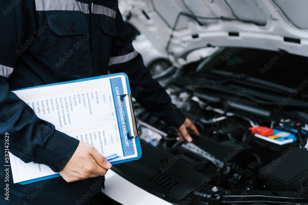 Automobile mechanic repairman checking a car engine by inspecting and ...