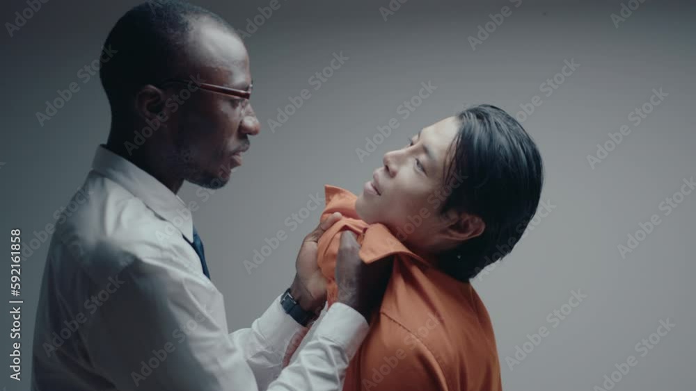 Vidéo Stock Furious black detective grabbing and threatening sly Asian ...