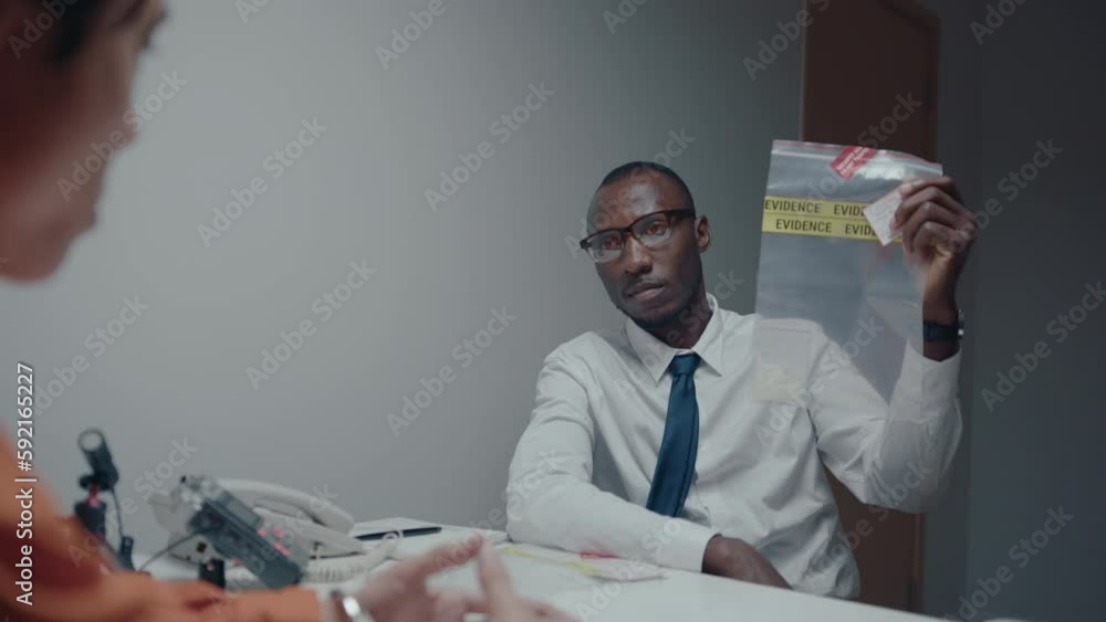 African American male detective showing drugs in an evidence plastic ...