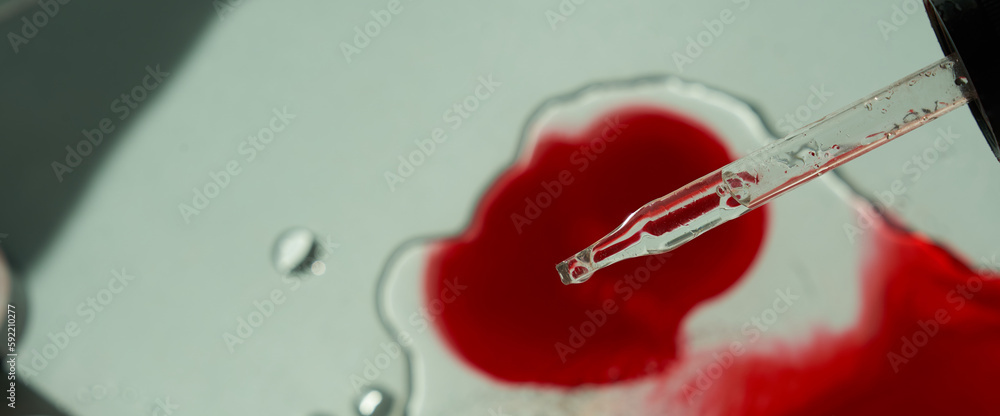 Red liquid with a pipette in the form of a spot in the container ...