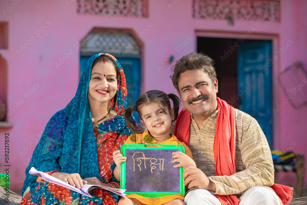 Foto de Indian rural couple with her little daughter showing chalk ...