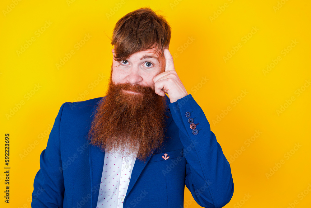 Photo & Art Print red haired man wearing blue suit over yellow studio background tries to ...