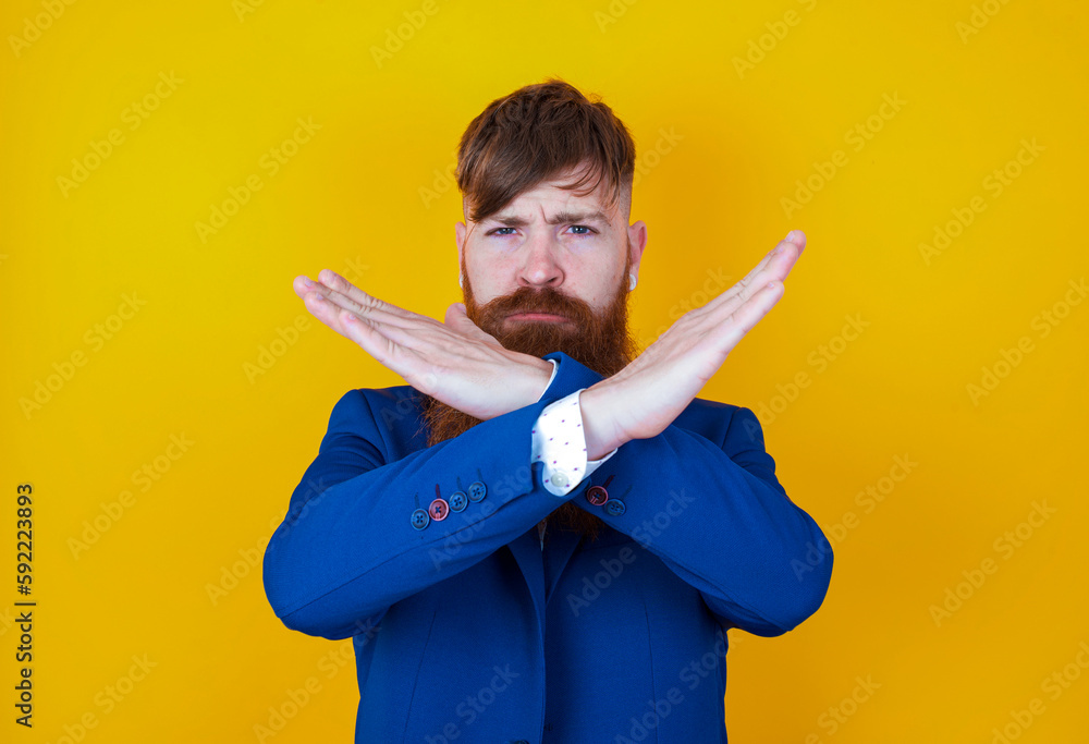 red haired man wearing blue suit over yellow studio background ...