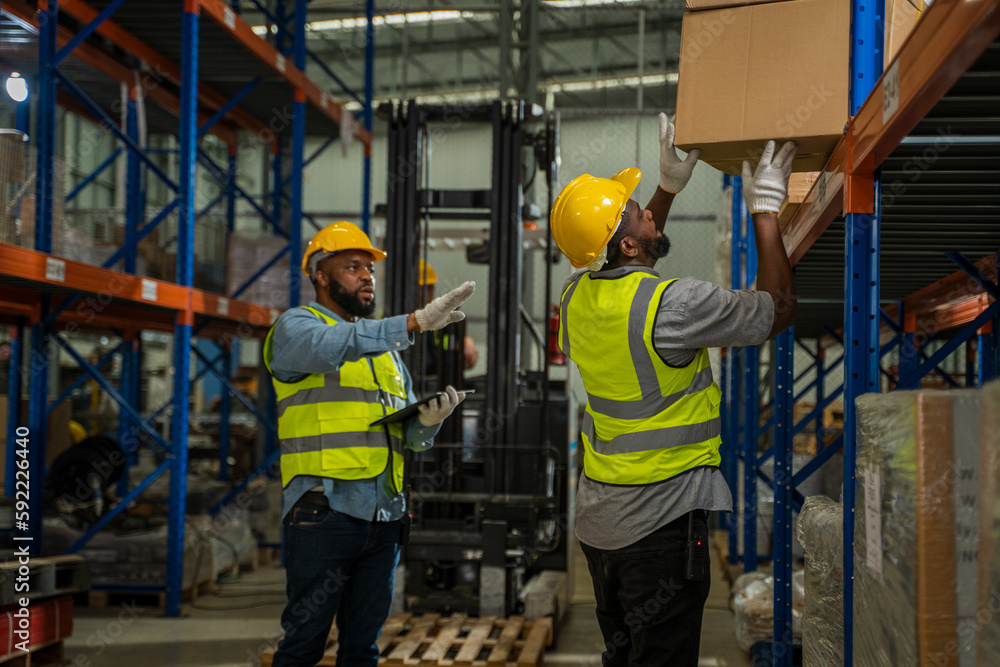 Warehouse worker checking and loading or unloading boxes in a large ...