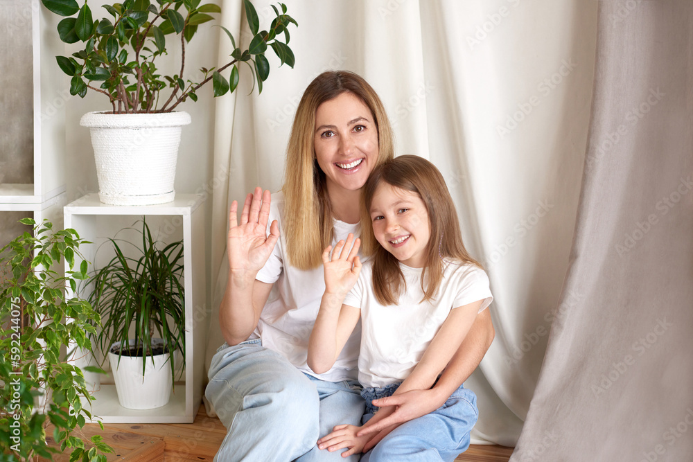 happy mother and daughter child wave hands to send hello to family or ...