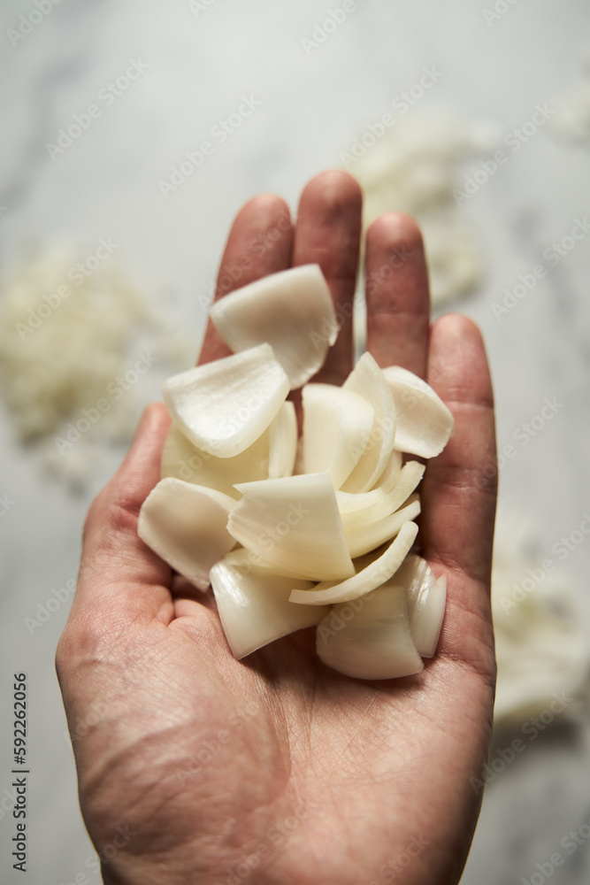 Chunk sliced onions on mans hand. Photo show how does onion sliced into ...