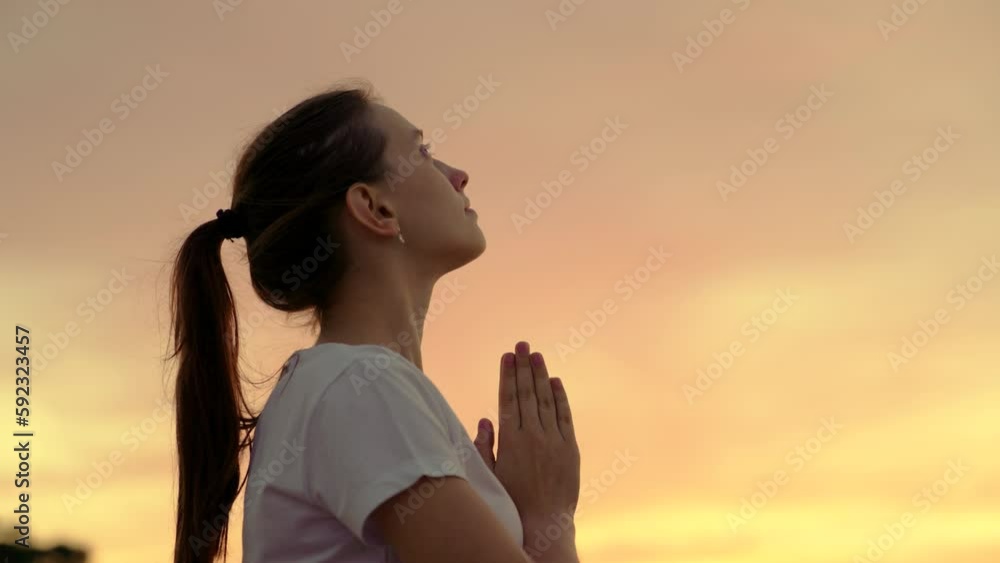 Young woman praying at sunset, Silhouette. Path of soul to God through ...