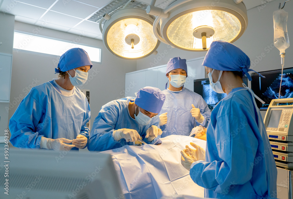 Operation team with blue clothes compose of nurse and doctor help to ...