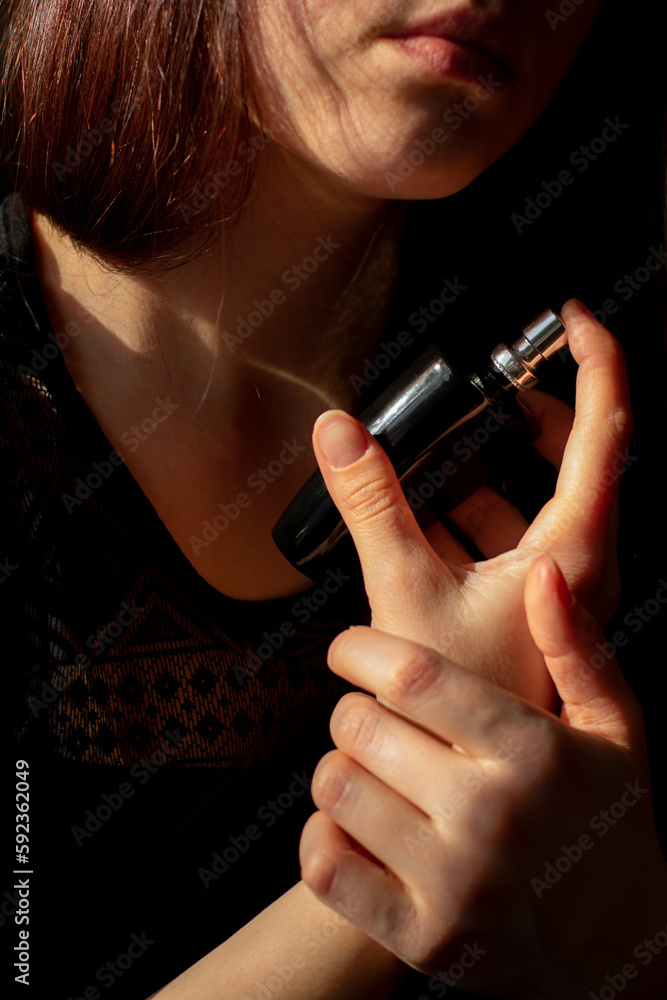 Young pretty woman with black glass bottle of sensual luxurious perfume ...