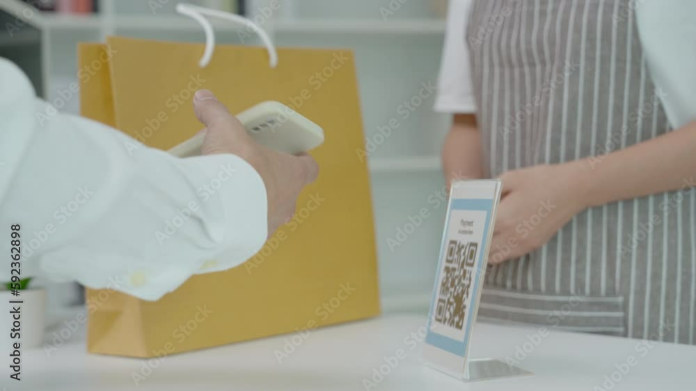 Vídeo do Stock: Customer use smartphones to scan QR codes to pay in-store with digital payments ...
