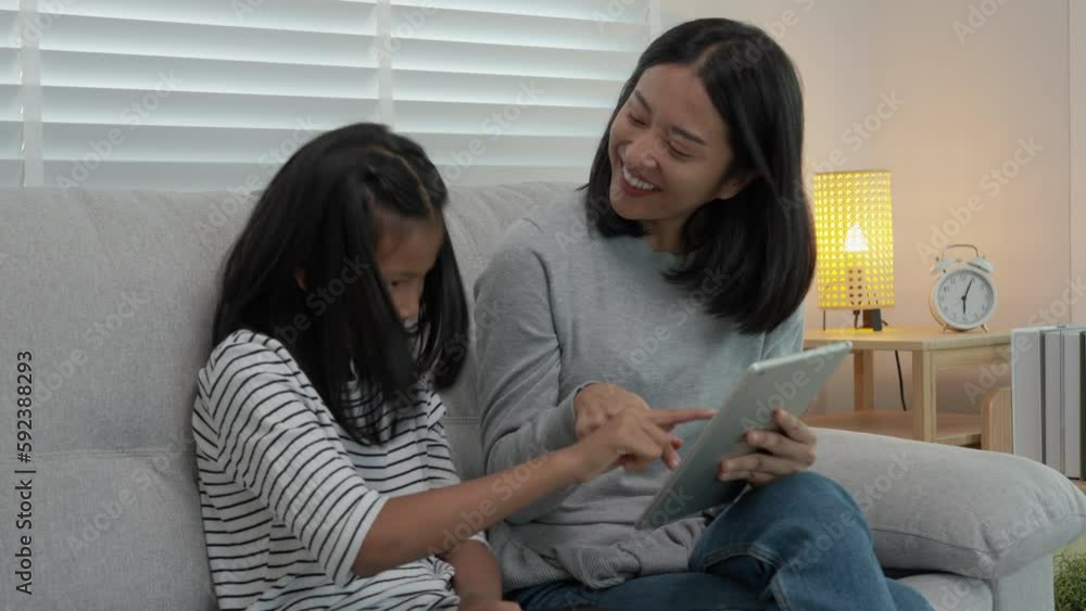 Mother teaching lesson for daughter by tablet. Mother and child ...