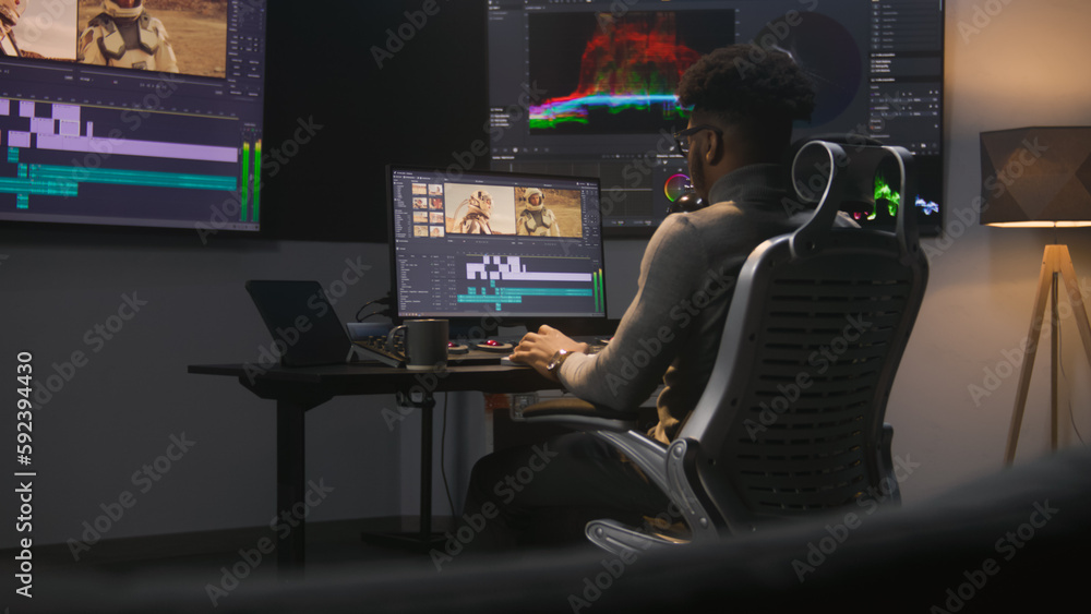 African American colorist makes color grading in video editing software ...