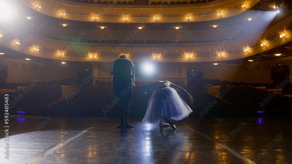 Pair of ballet dancers bow down in front of rows of seats. Ballerina ...