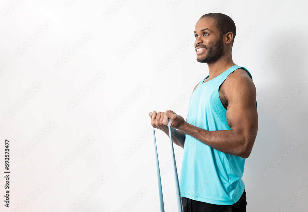 Dark-skinned muscular man poses on a white background in sportswear ...