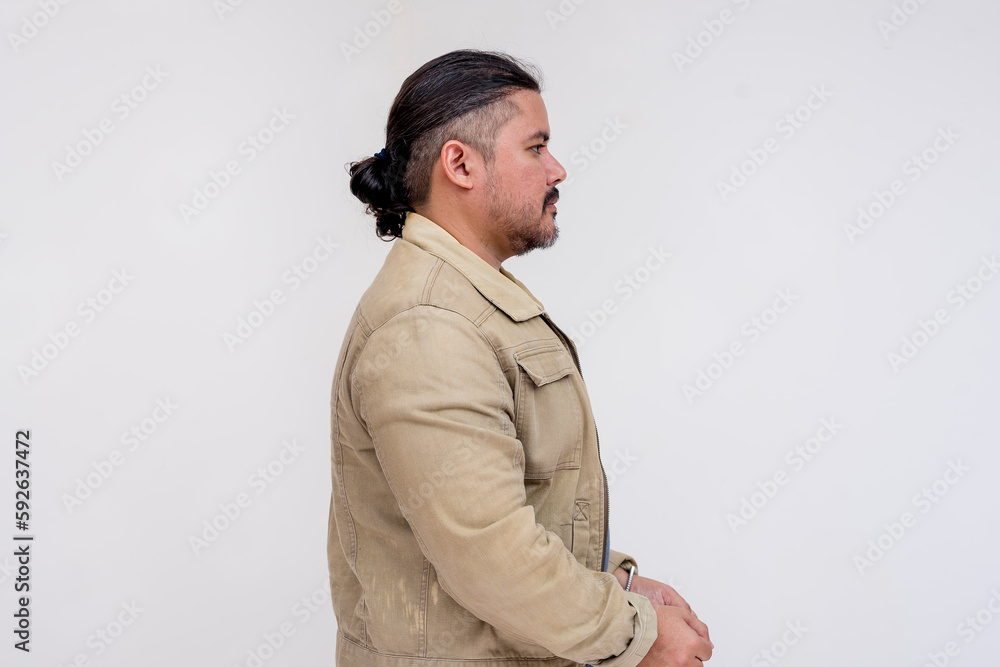 Side view of a man with long tied hair and in a jacket detained and ...