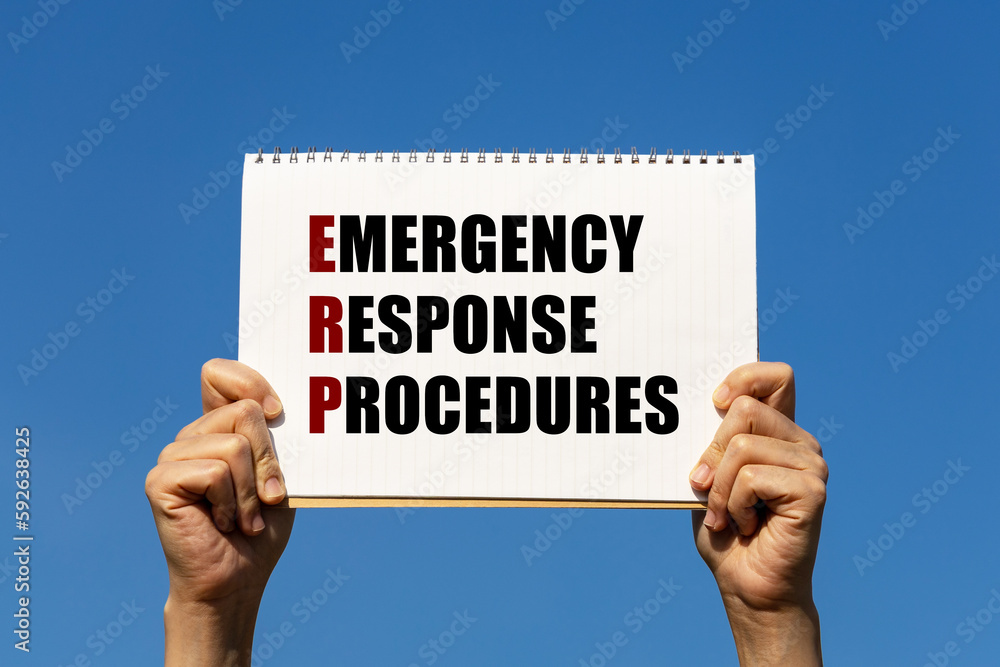 Emergency response procedures text on notebook paper held by 2 hands ...