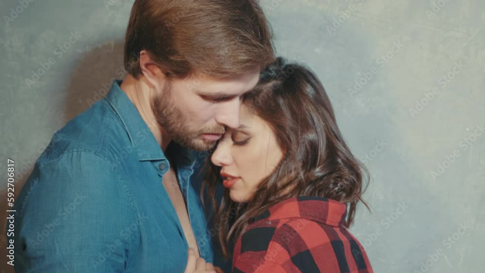 Hot beautiful woman and her handsome boyfriend. Models posing near grey ...