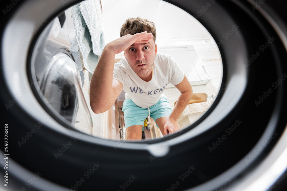 Man view from washing machine inside. Male does laundry daily routine ...