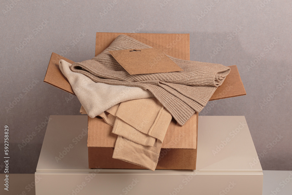 Foto de Cardboard box with used wardrobe for reuse. Second hand apparel ...