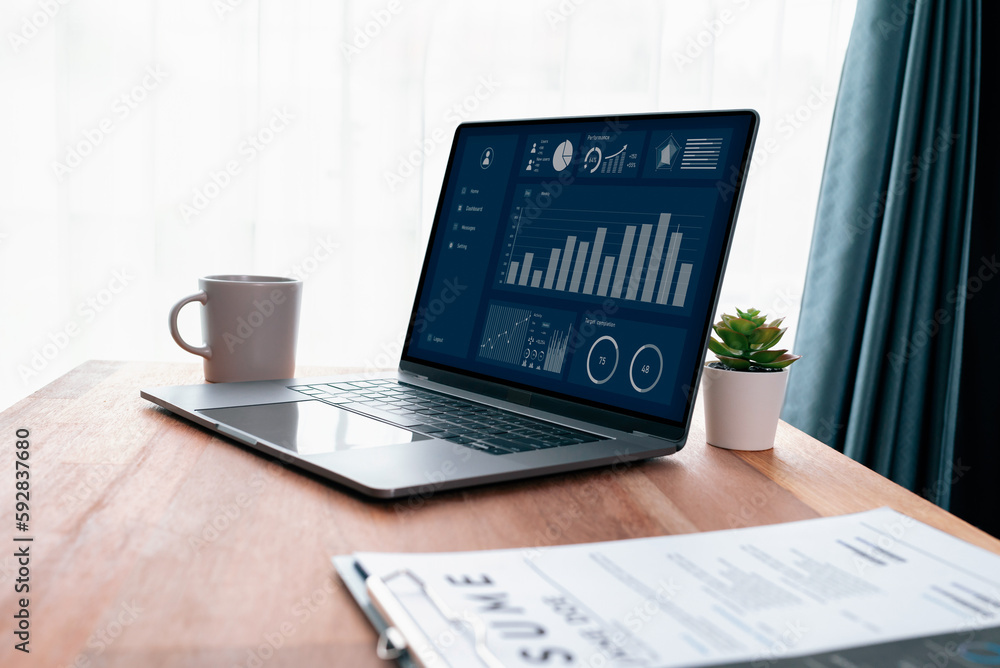 Wooden desk in office with laptop displaying Fintech dashboard business ...