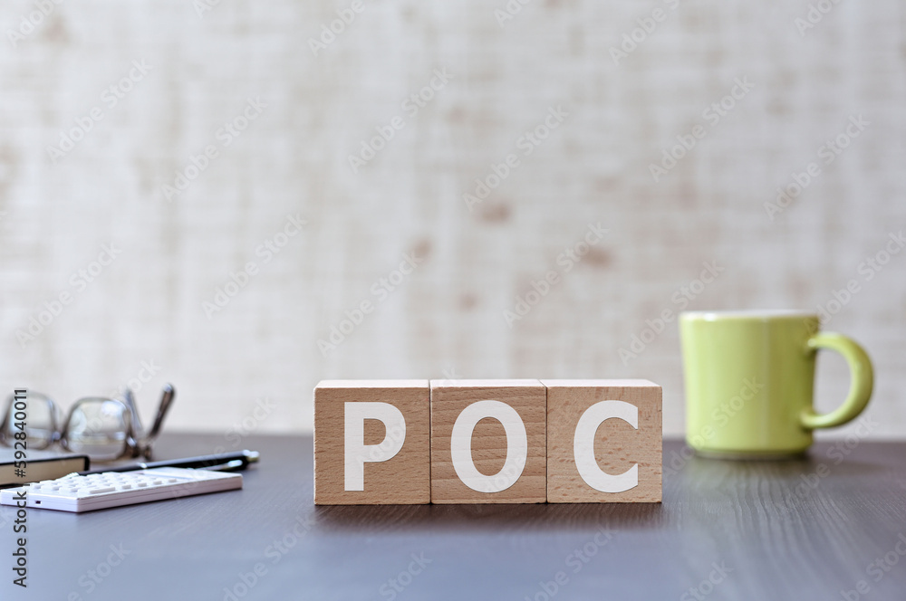 There is wood cube with the word POC. It is an acronym for Proof of ...