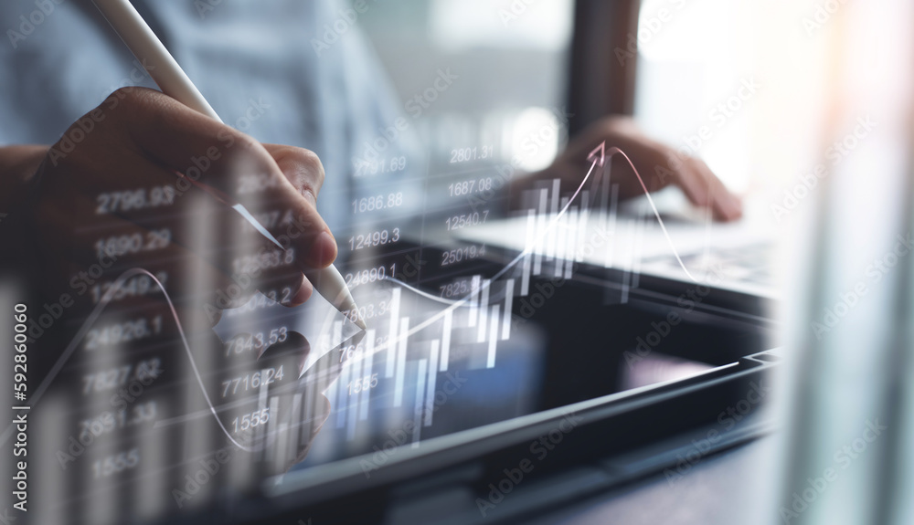 Businessman using digital tablet analyzing sales data and economic ...
