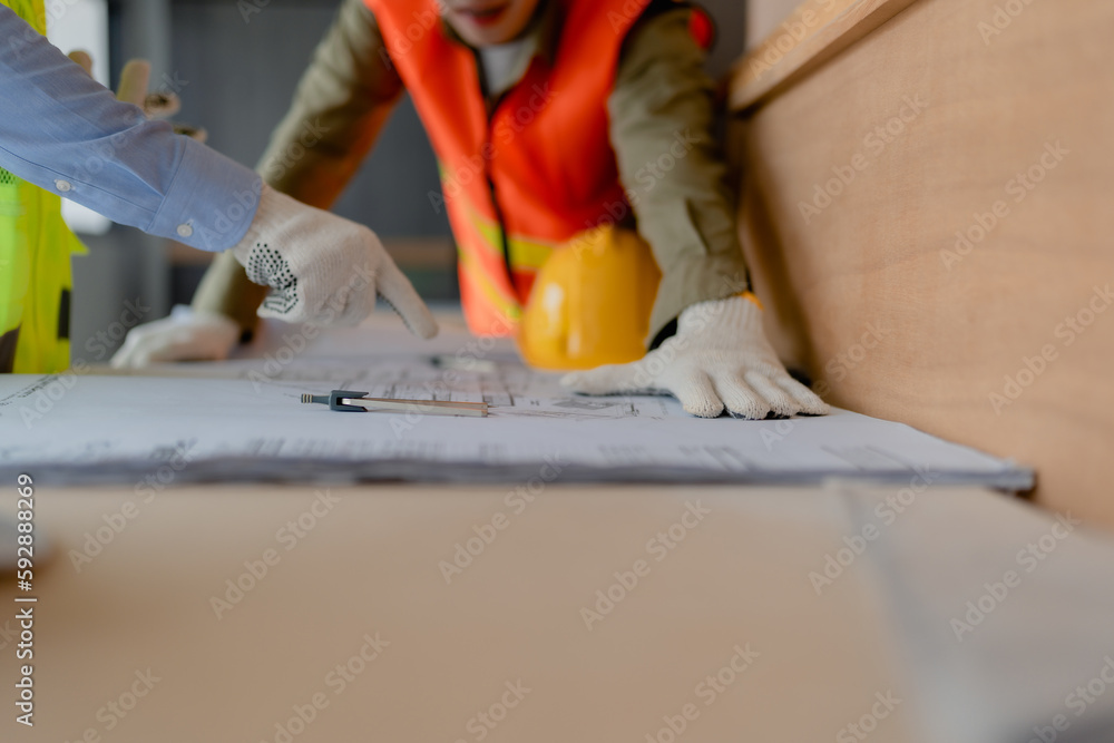 multi ethnic engineer brainstorming and measuring for cost estimating ...