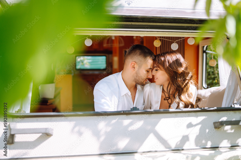 Newly made couple are resting in a trailer. Newlyweds tenderly embrace ...