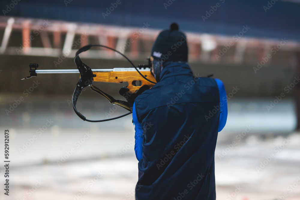 Biathlete with rifle on a shooting range during biathlon training ...