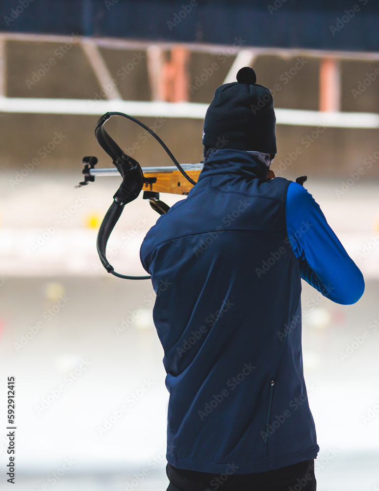 Biathlete with rifle on a shooting range during biathlon training ...