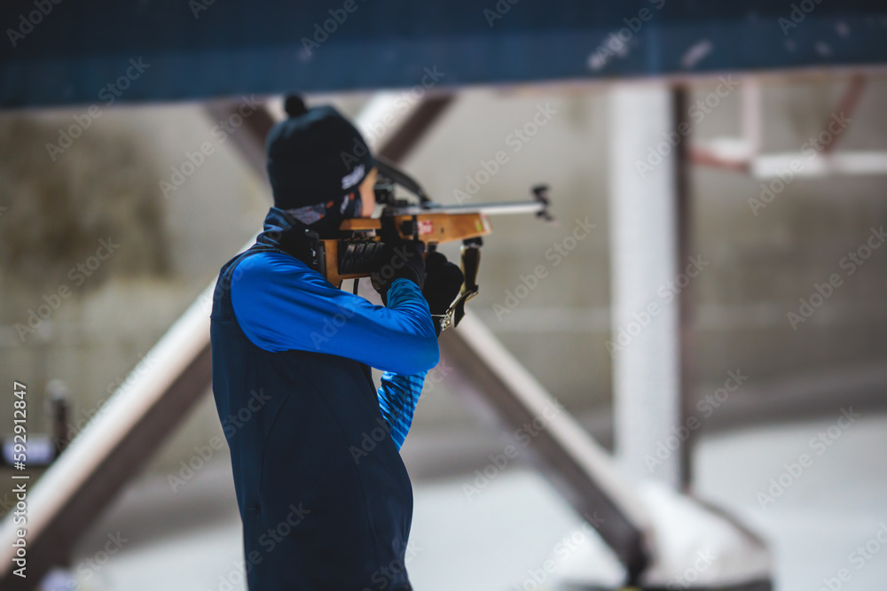 Biathlete with rifle on a shooting range during biathlon training ...