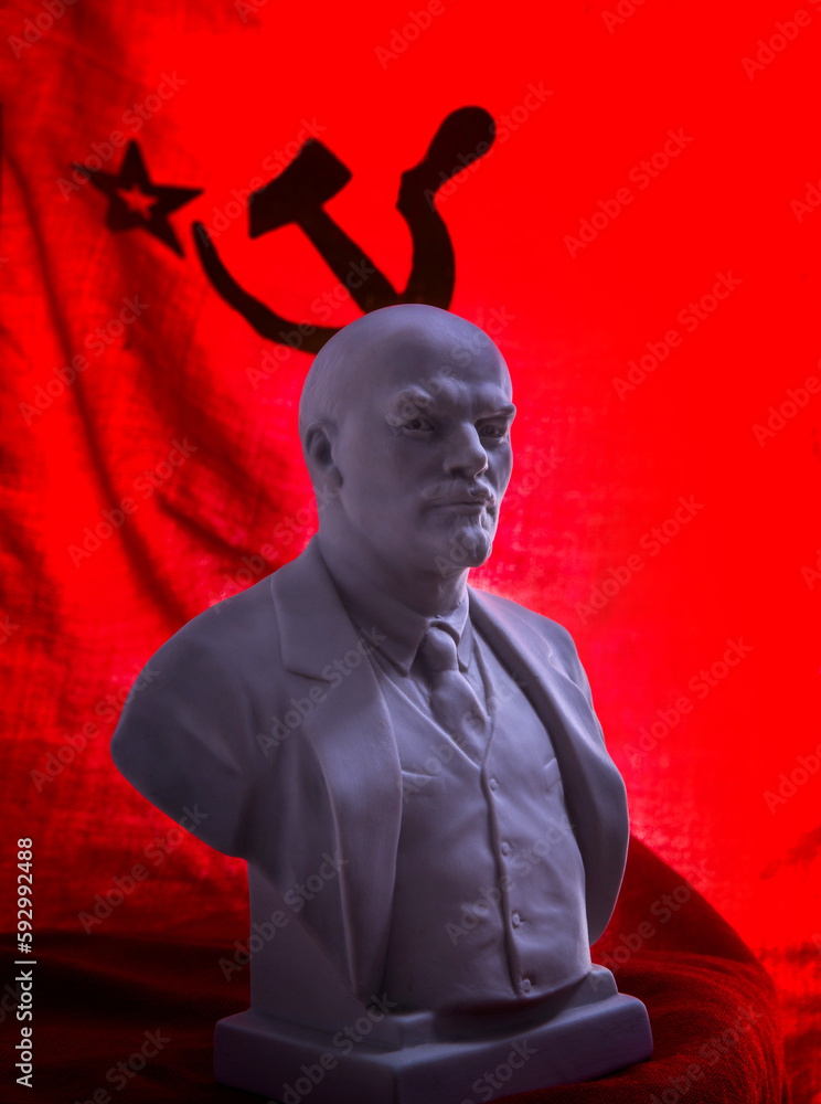 Ceramic bust of Lenin against the background of the red flag of the ...