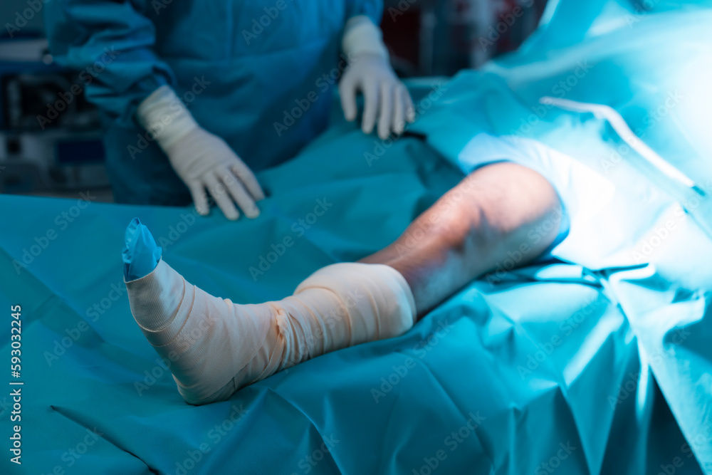 Patient's legs are straightened on bed In clean and safe operating room ...