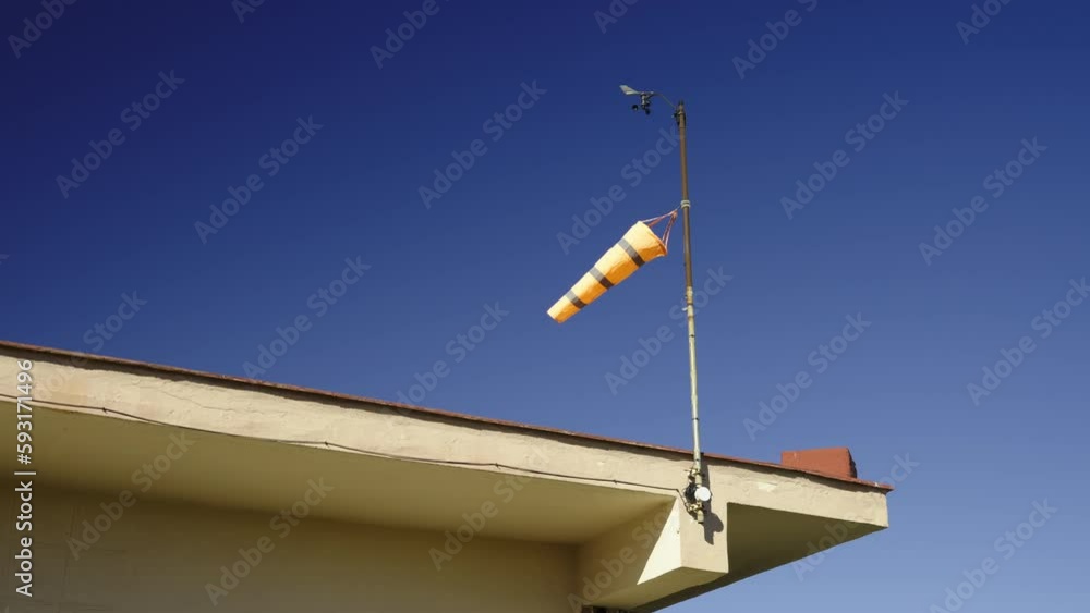 A striped cone to determine the direction of the wind against a blue ...